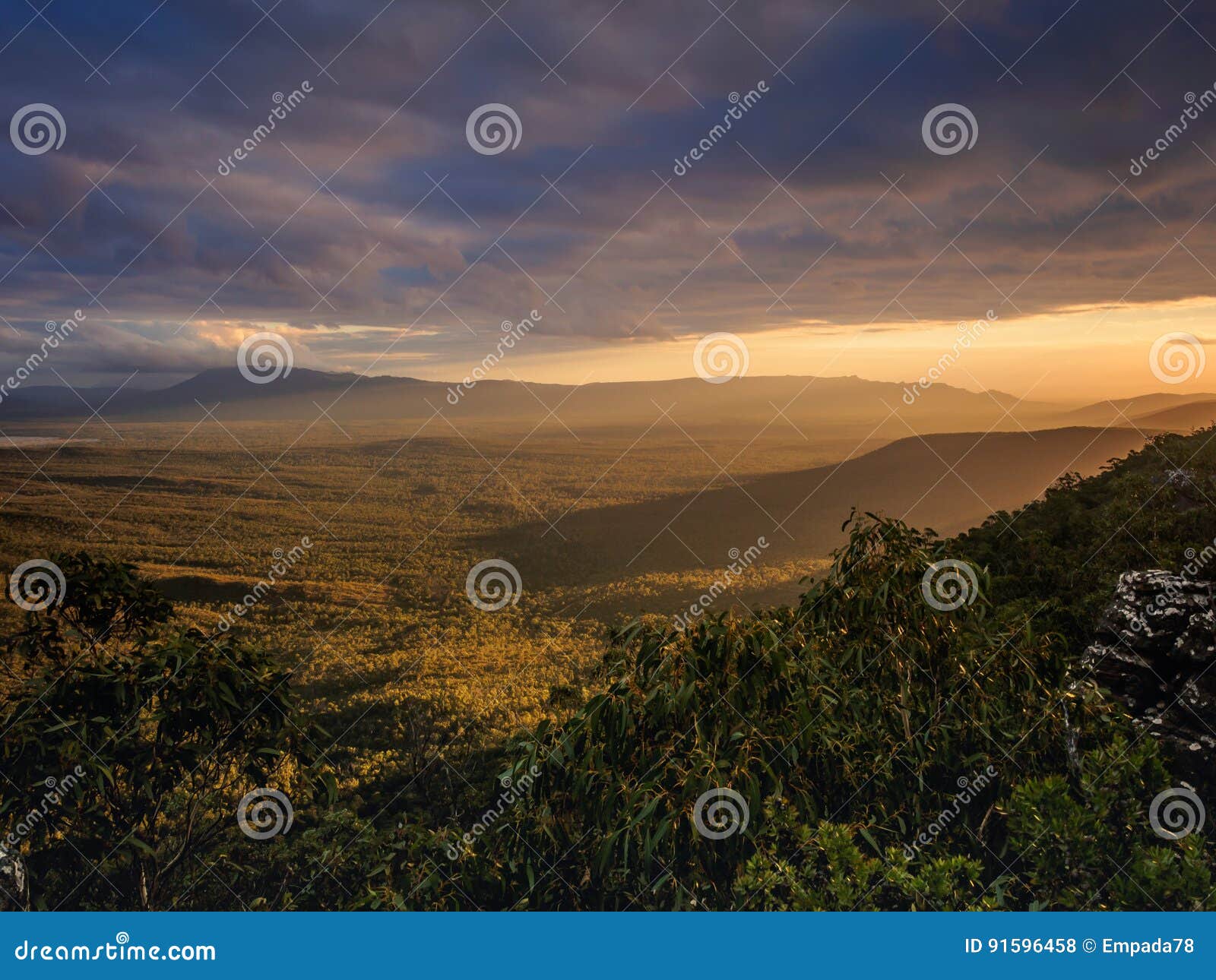 Rays of Light from Setting Sun Over Mountain Valley Stock Photo - Image ...