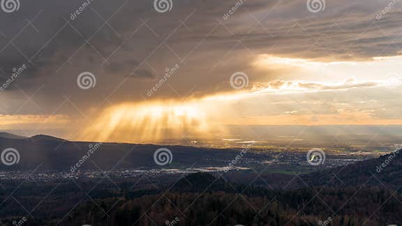 The Rays of the Setting Sun Transform an Approaching Rain Shower into a ...