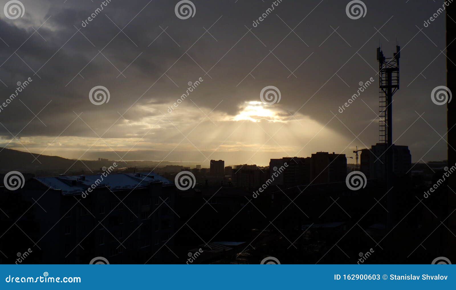The Rays of the Sun Fall on the City in Cloudy Weather. Stock Image ...