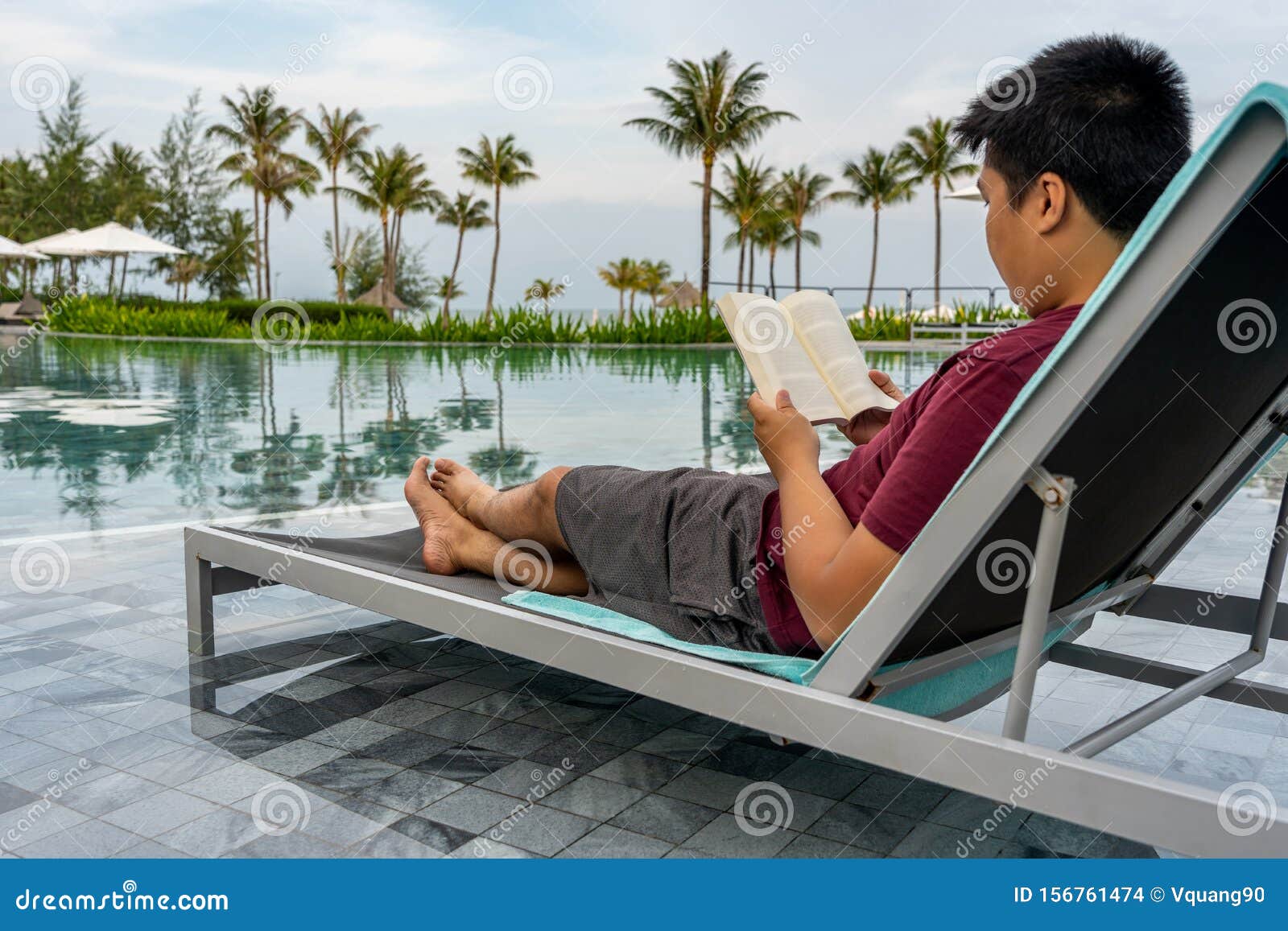 Reading Book at Beautiful Swimming Pool by the Beach Stock Photo ...