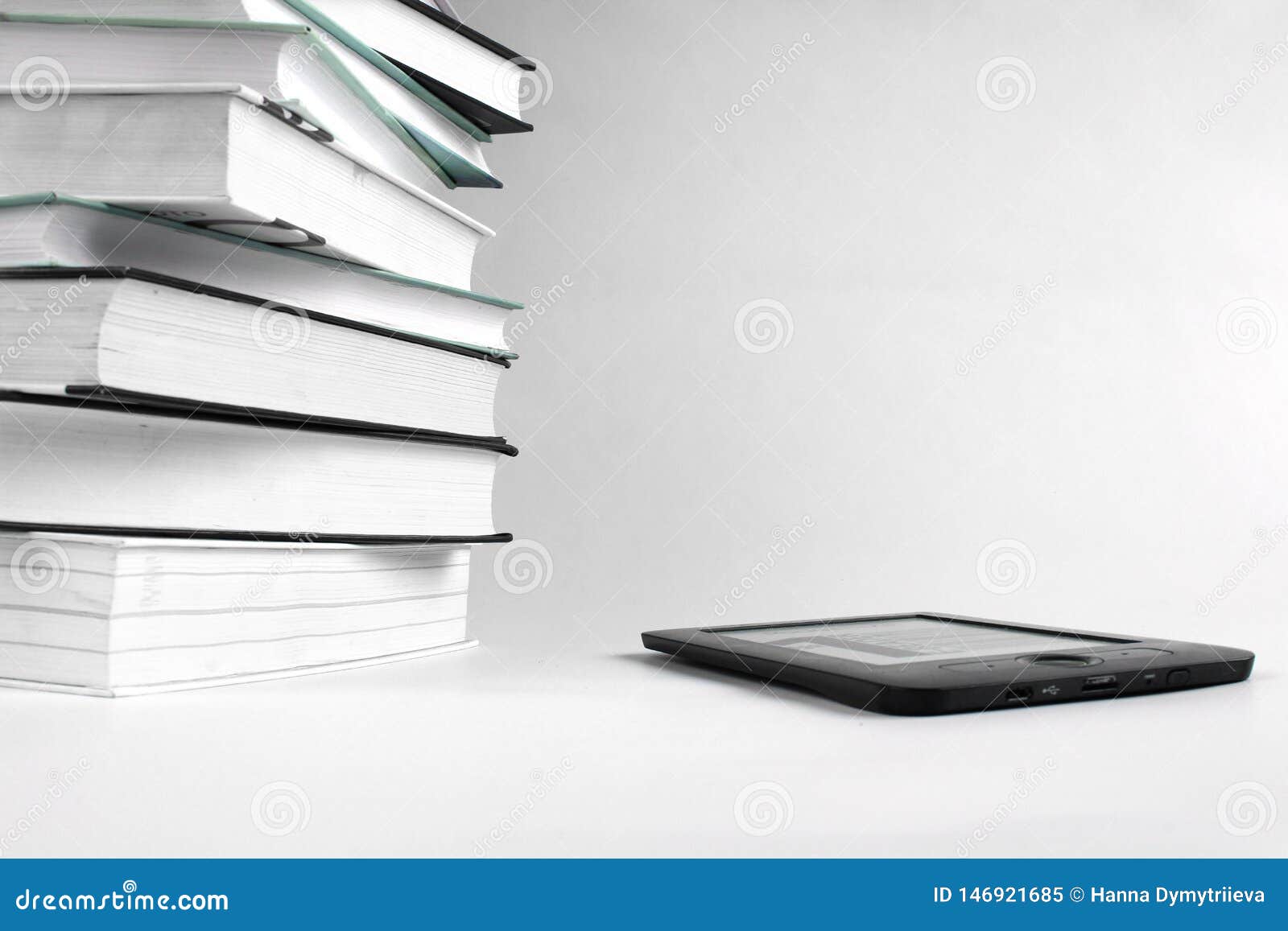 Reading Books with an E-book. Stack of Books and E-book on White ...