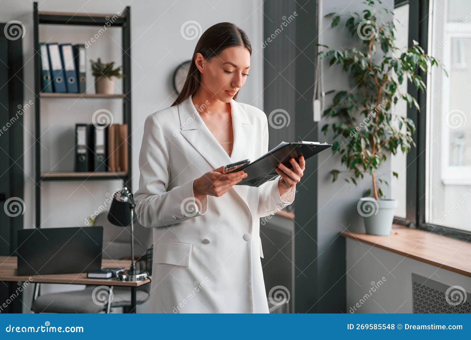 Reading Document in Notepad. Young Beautiful Woman in Formal Clothes is ...