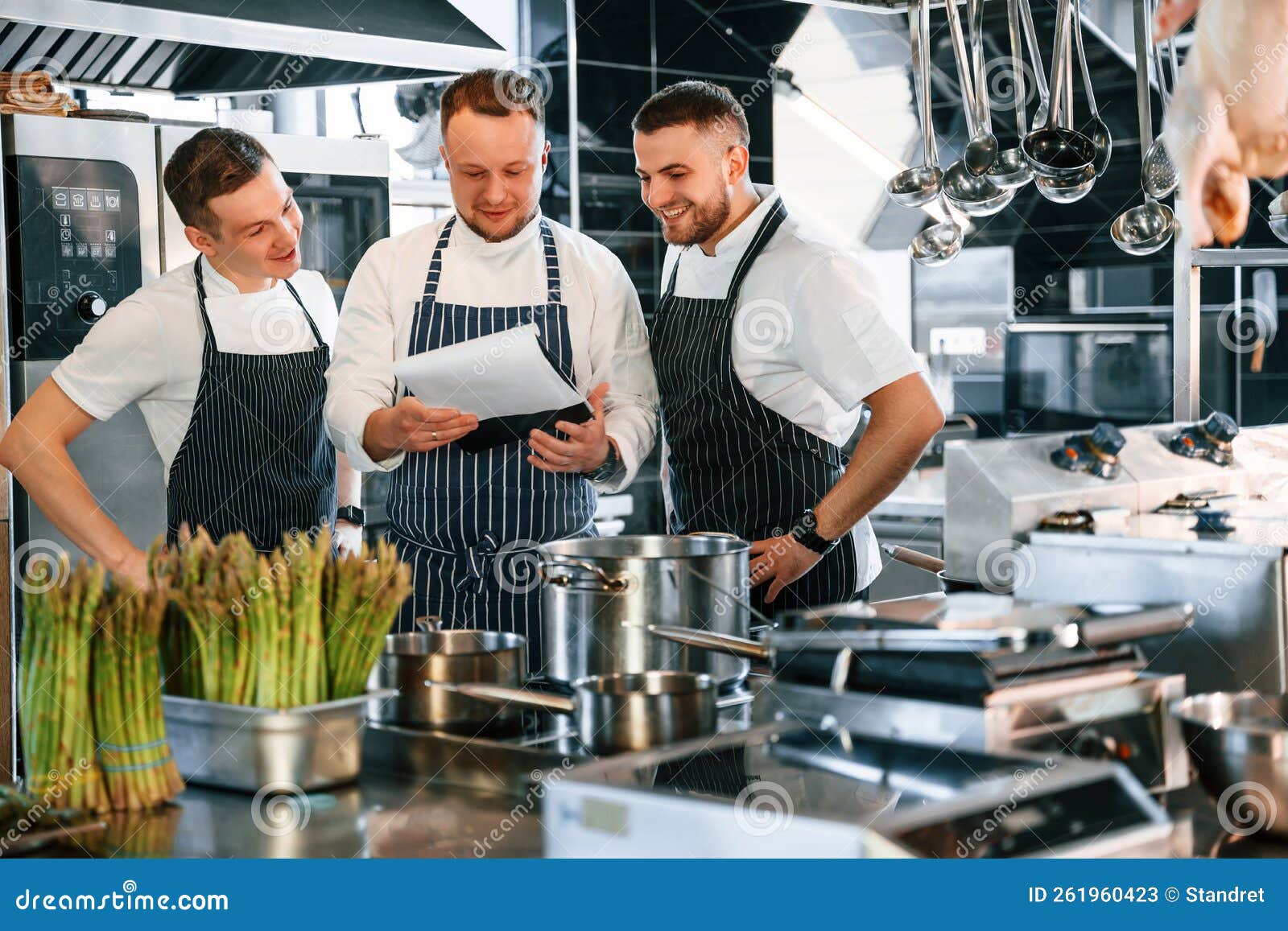 Reading the Documents. Kitchen Workers is Together Preparing the Food ...