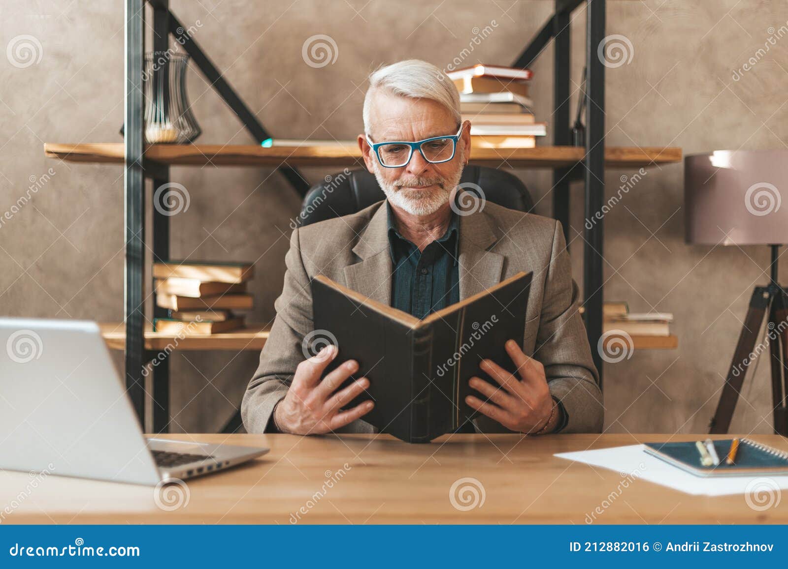 Reading in the Home Library. an Elderly Man is Reading a Book at the ...