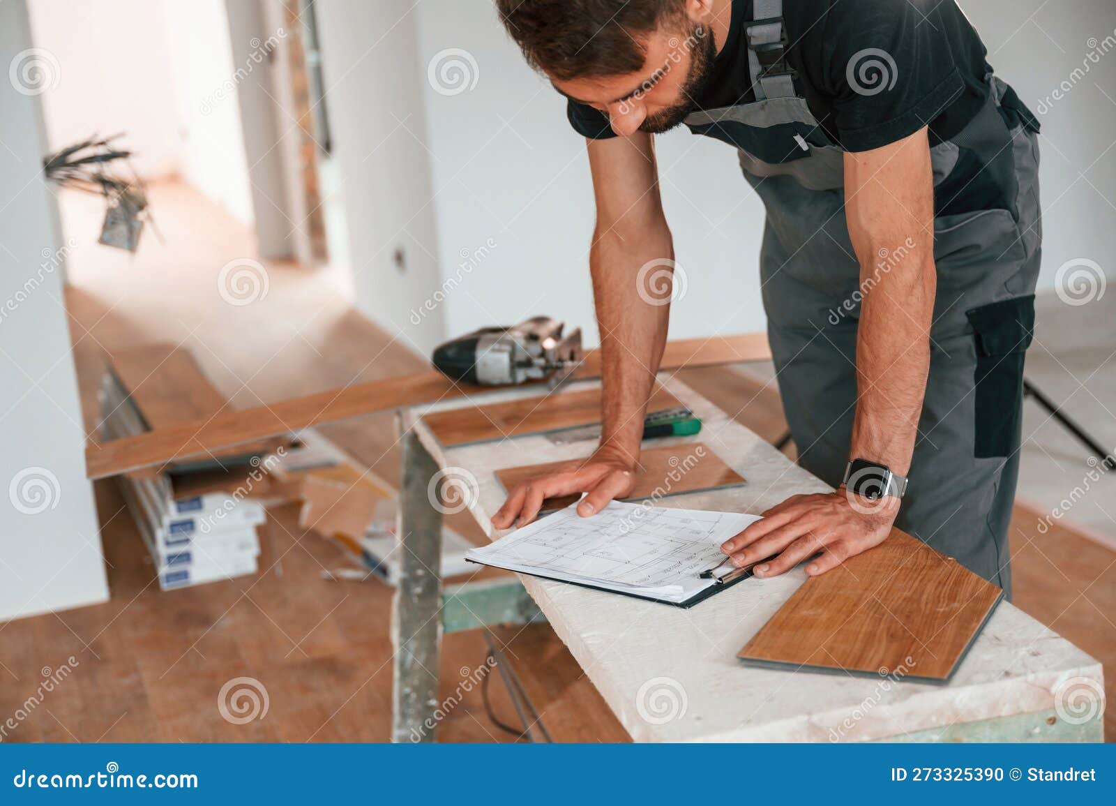 Reading the Information. Man is Installing New Laminated Wooden Floor ...