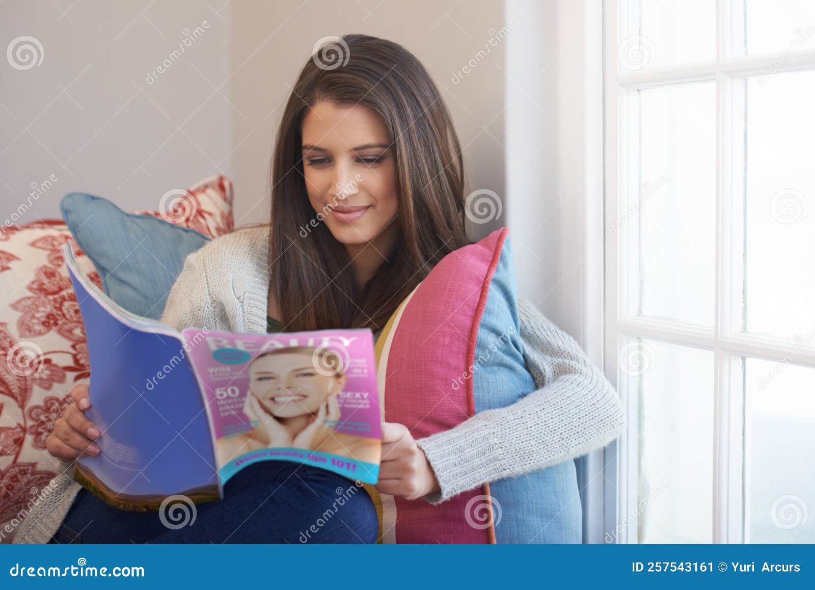 Reading an Interesting Article. a Young Woman Reading a Book at Home ...