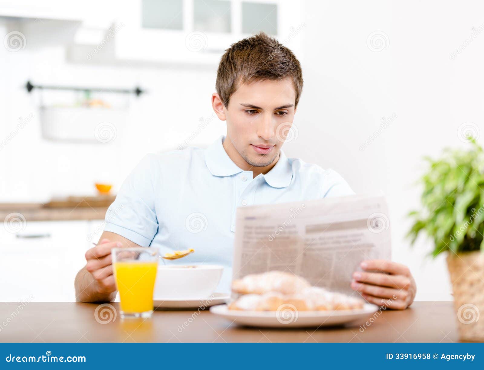 Reading Man Eats Light Breakfast in Kitchen Stock Photo - Image of ...