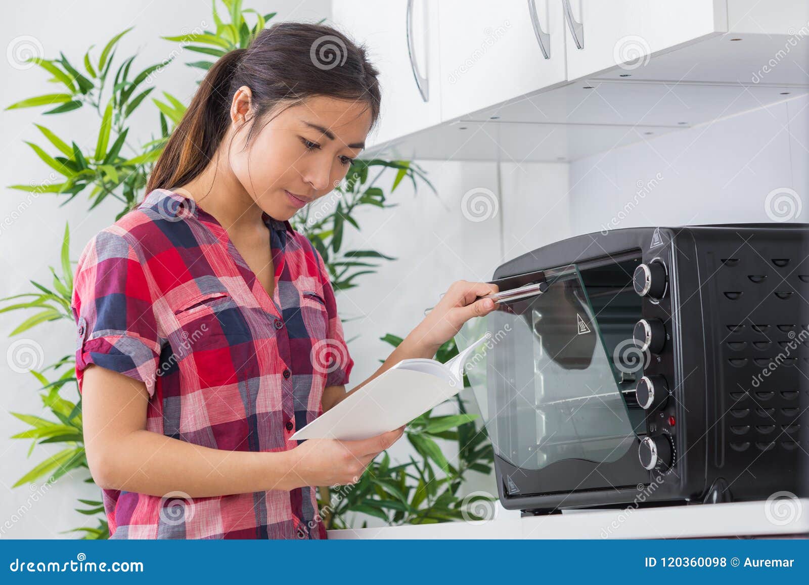 Reading the oven`s manual stock photo. Image of feature - 120360098