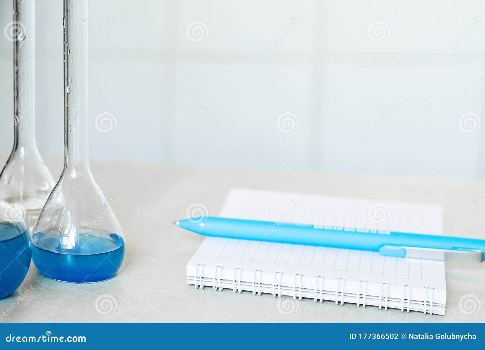 Reagents in Flasks, Notebook and a Pen on a Table in a Chemical ...