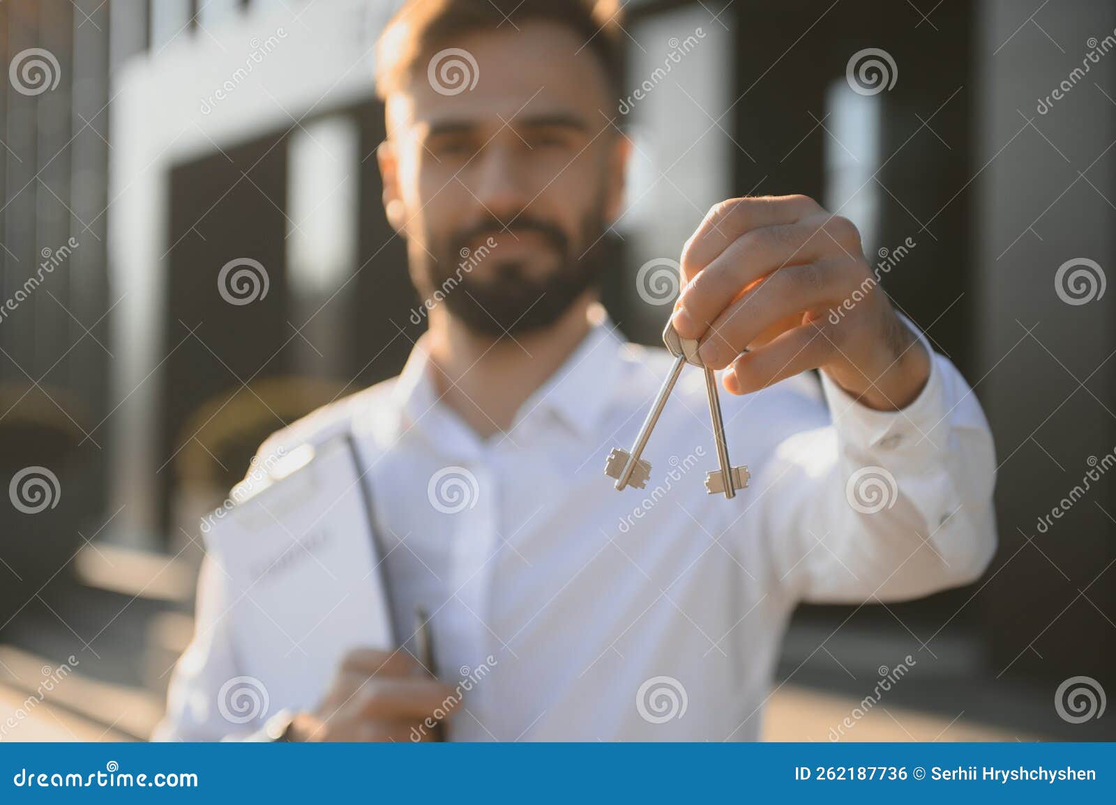 Real Estate Agent Holding Key on Blurred Background, Closeup Stock ...