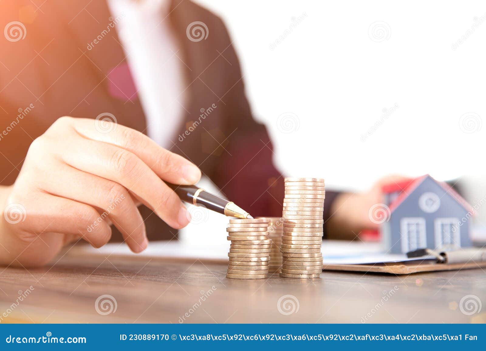 Real Estate Practitioners Stack Coins and Tables on the Small House ...
