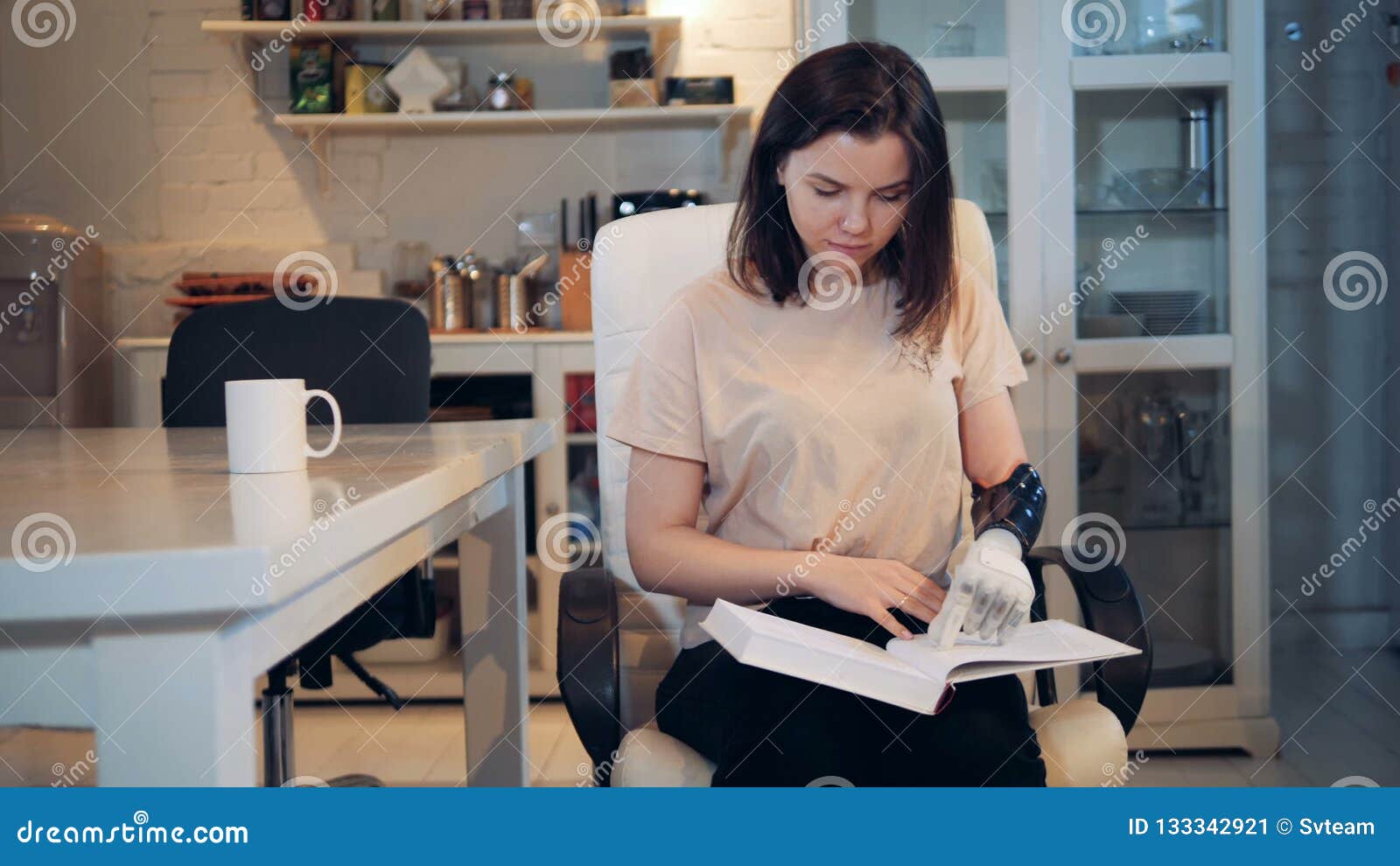 Real Robotic Human-like Arm. a Lady with a Prosthetic Arm Opens a Book ...