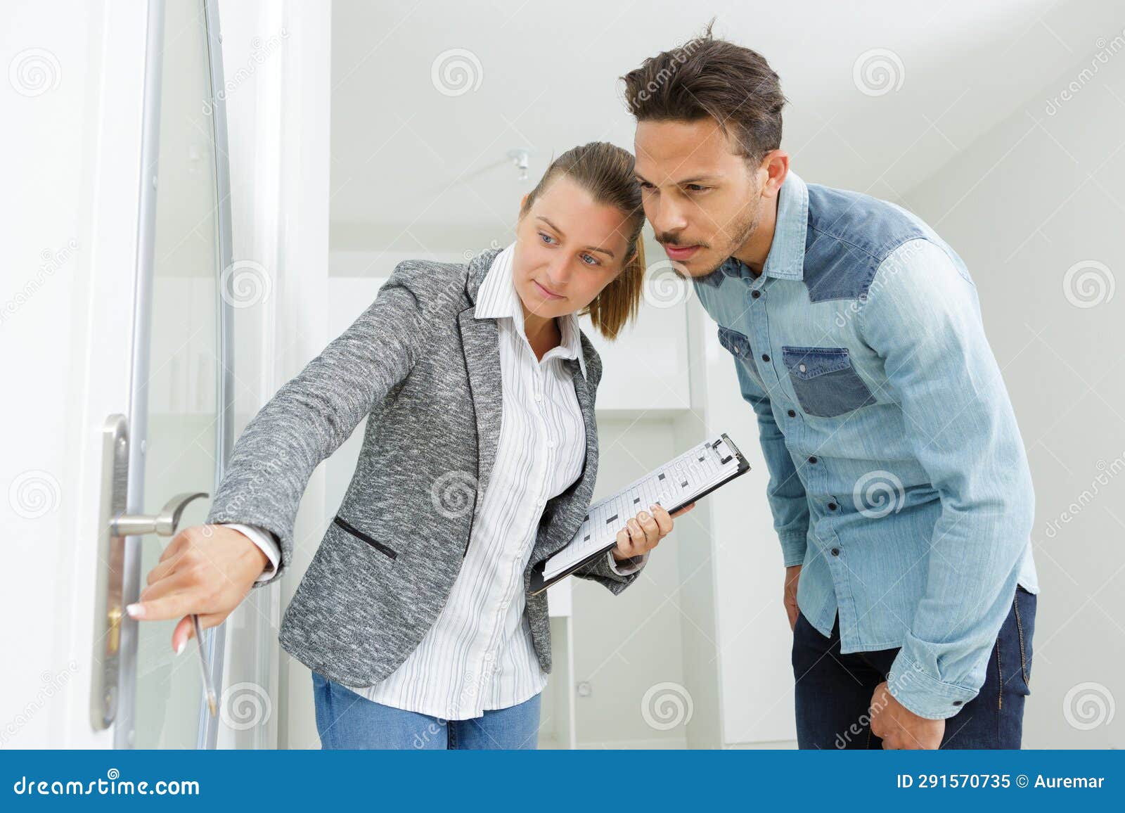 Realtor Pointing at Door Lock while Visiting Property with Client Stock ...