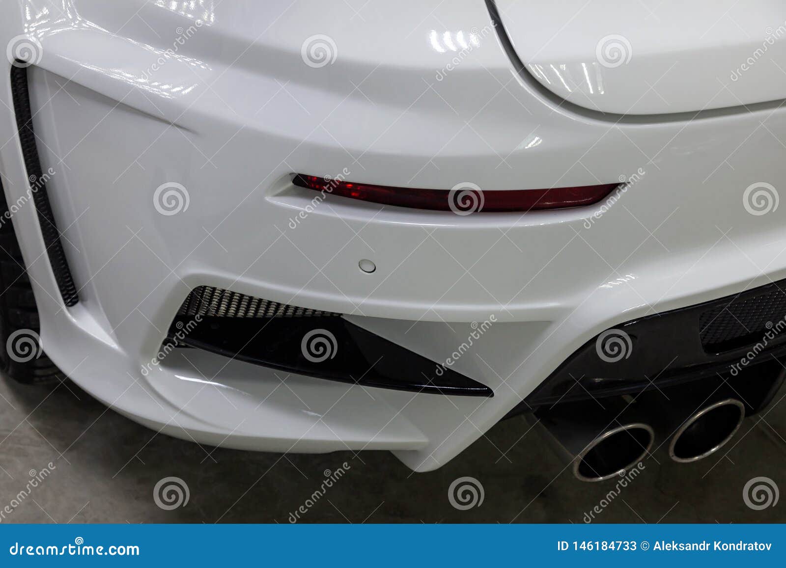 The Rear Bumper of a Tuned Car is White with a Double Exhaust Nozzle, a ...