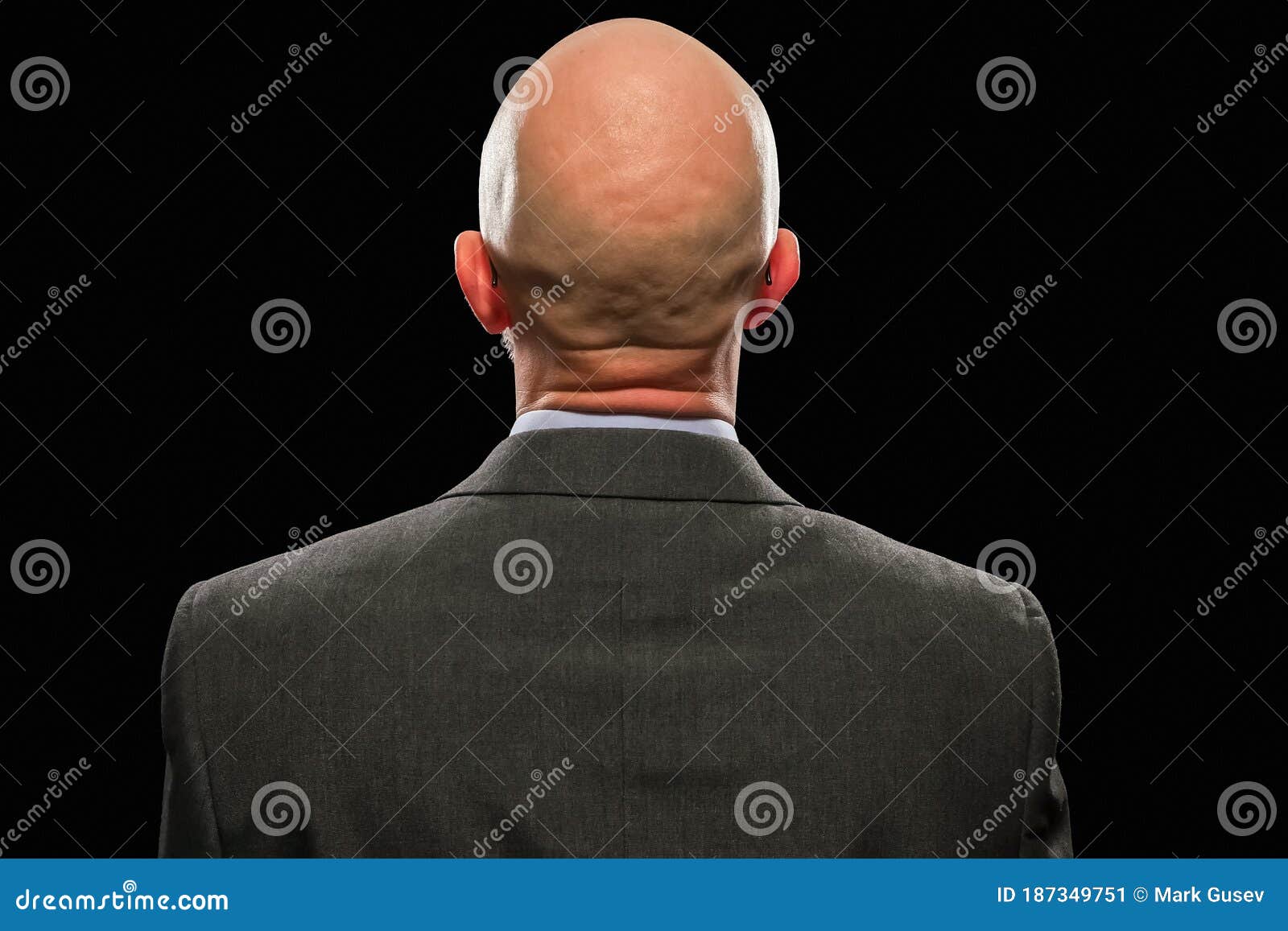 Rear View of a Bald Businessman in a Grey Suit on a Dark Background ...