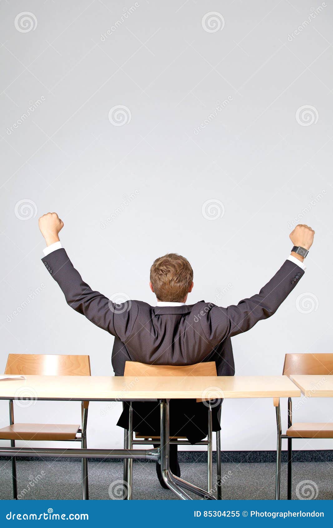 Rear View of Businessman Sitting in Office with Outstretched Stock ...
