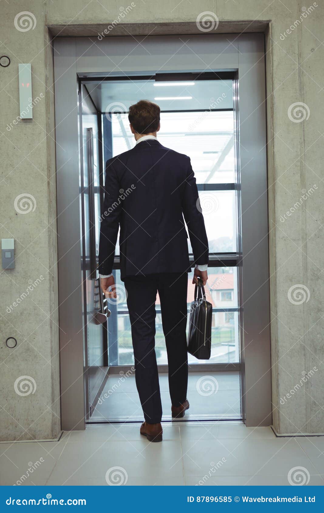 Rear View of Businessman Walking into an Elevator Stock Image - Image ...