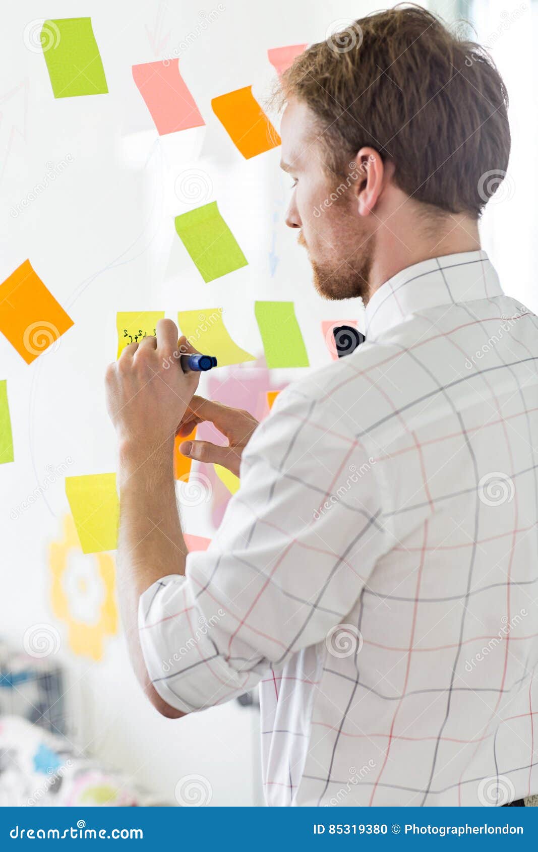 Rear View of Businessman Writing on Sticky Paper at Creative Office ...