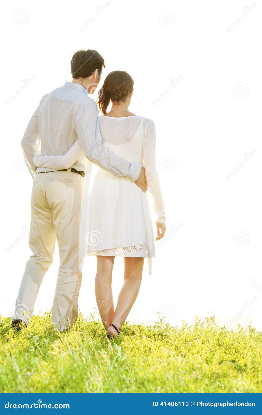 Rear View of Couple Standing Arms Around Against Clear Sky Stock Photo ...