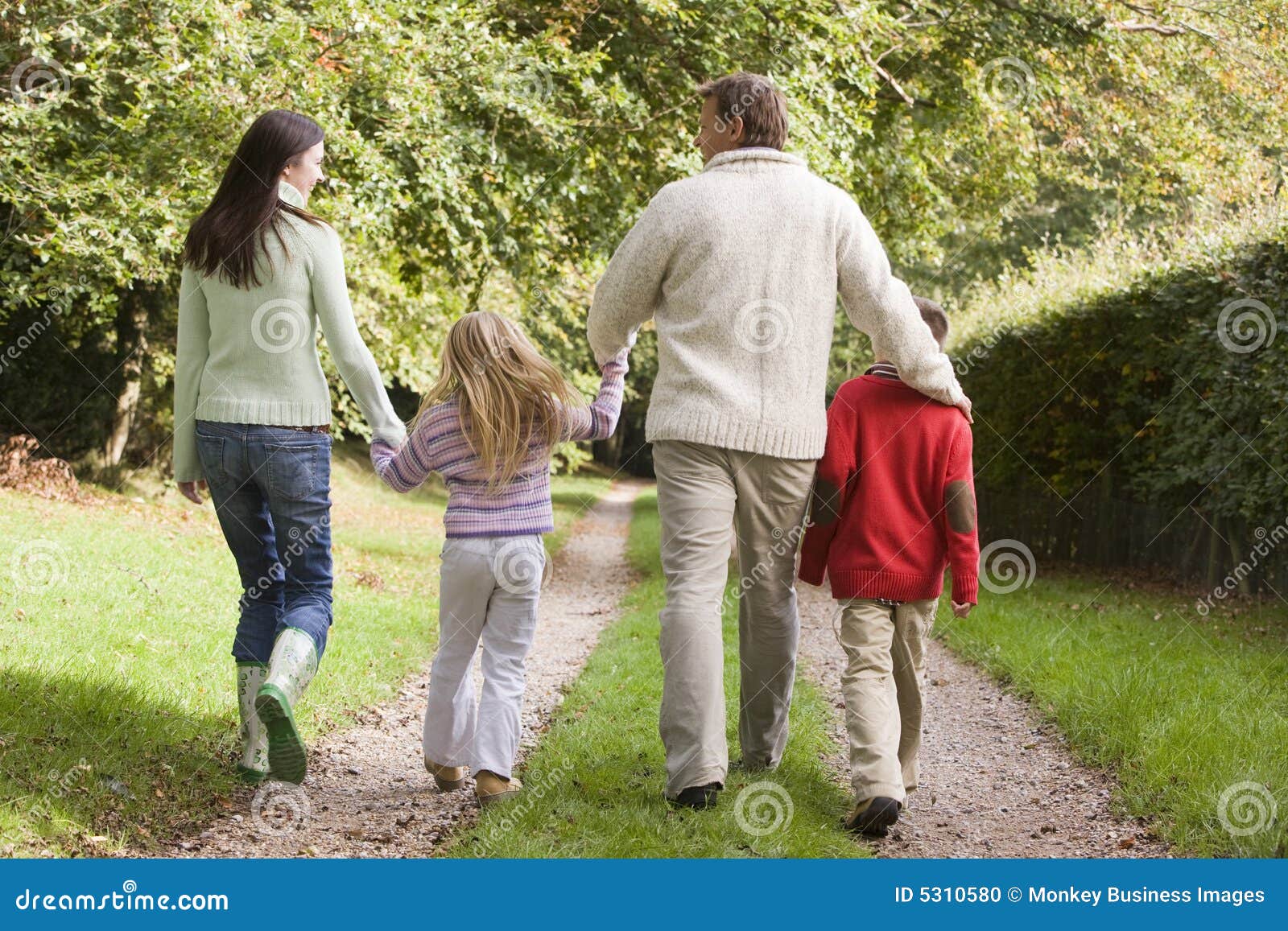 Rear View of Family Walking Along Track Stock Photo - Image of leaves ...