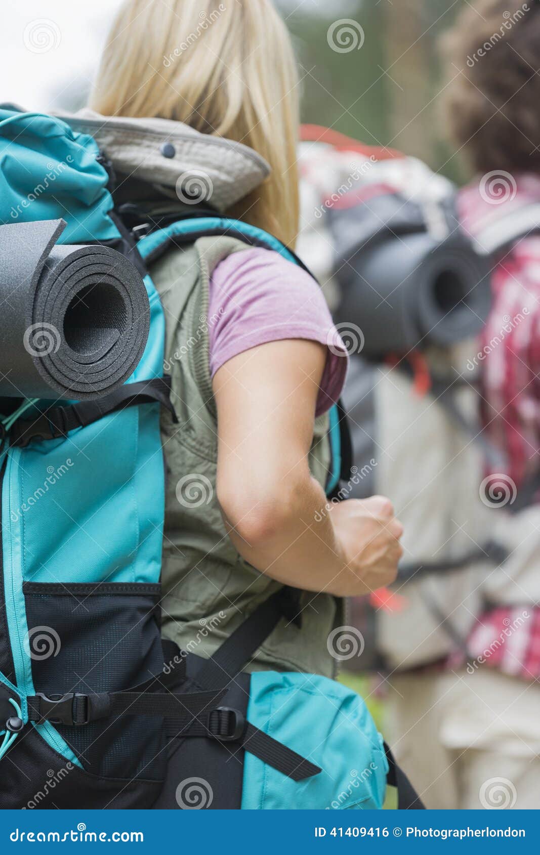 Rear View of Female Hiker Carrying Backpack with Man in Background ...