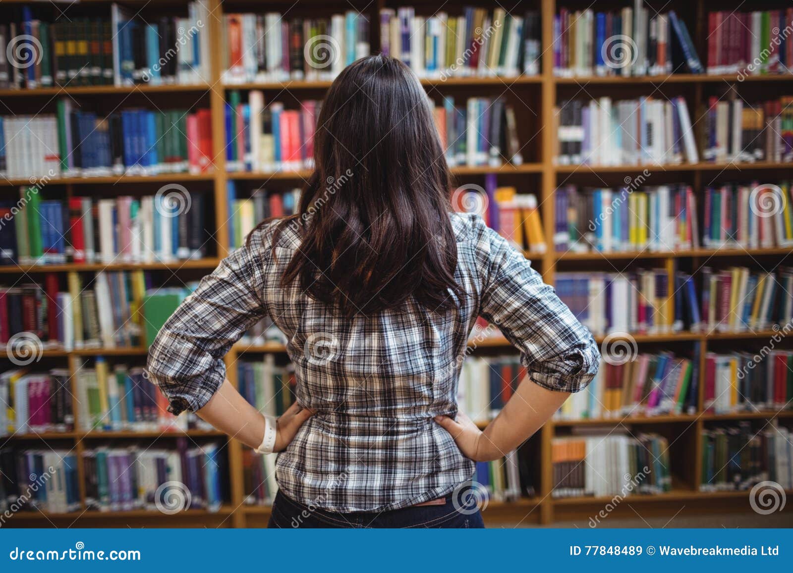 Rear View of Female Student Looking at Books in the Shelf Stock Image ...