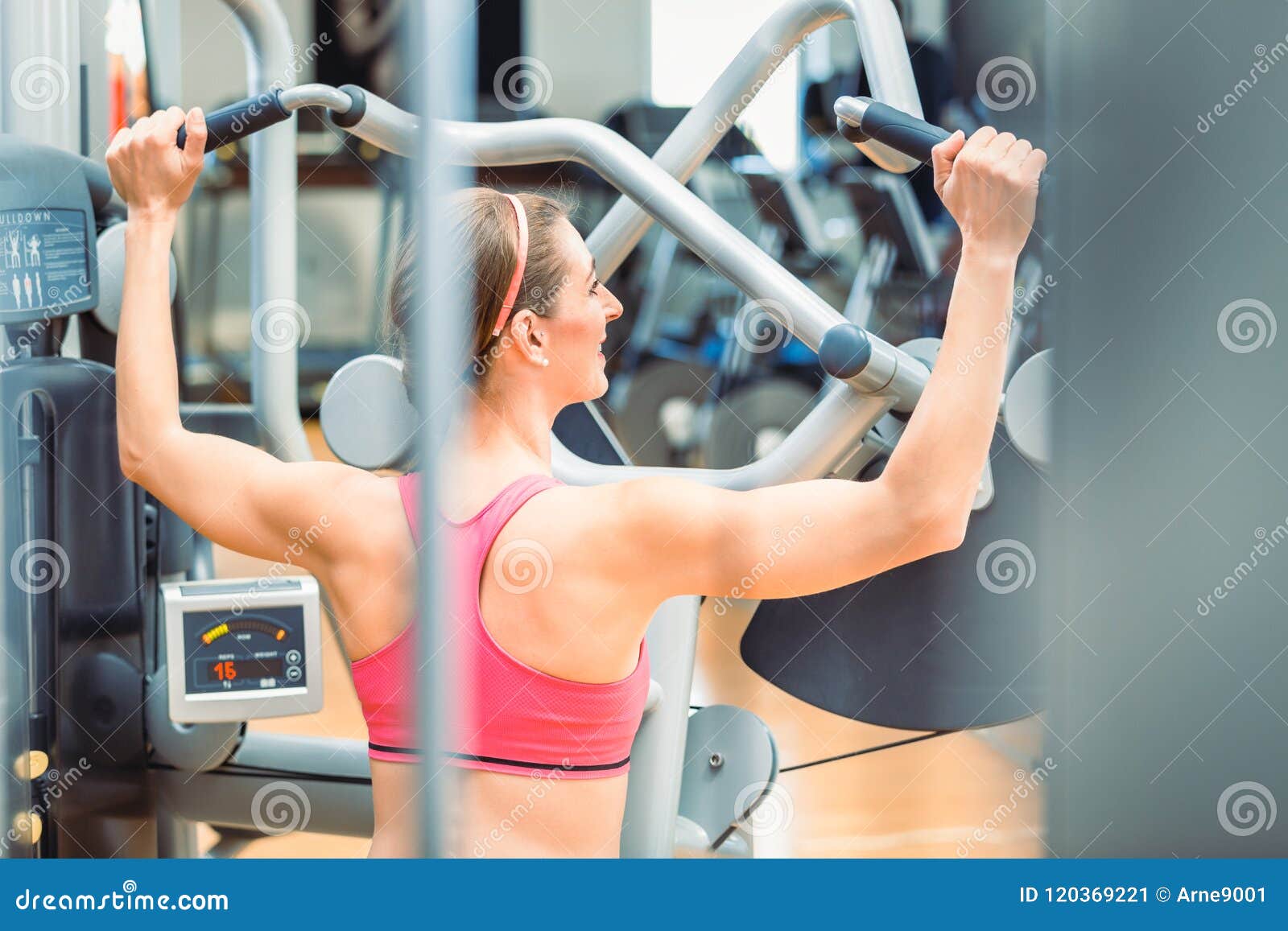 Rear View of a Fit Woman with Toned Arms and Back Exercising at the Gym ... Rear View of a Fit Woman with Toned Arms and Back Exercising at the Gym ...