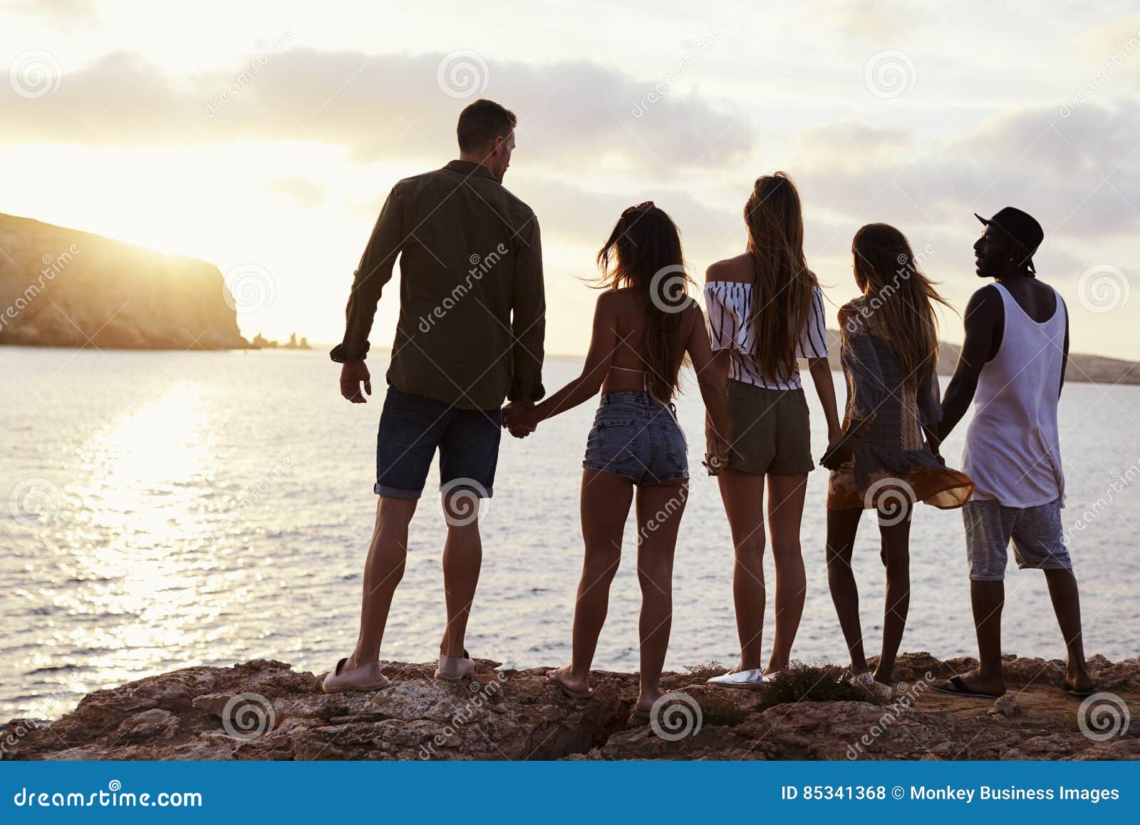 Rear View of Friends Standing on Cliff Watching Sunset Stock Photo ...