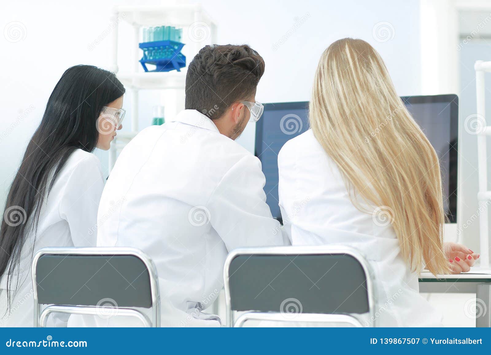 Rear View.a Group of Scientists Use Computers To Analyze Information ... Rear View.a Group of Scientists Use Computers To Analyze Information ...
