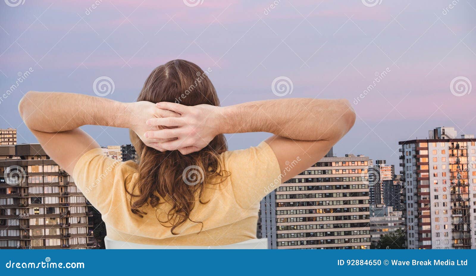 Rear View of Hipster with Hands Behind Head Against Buildings Stock ...