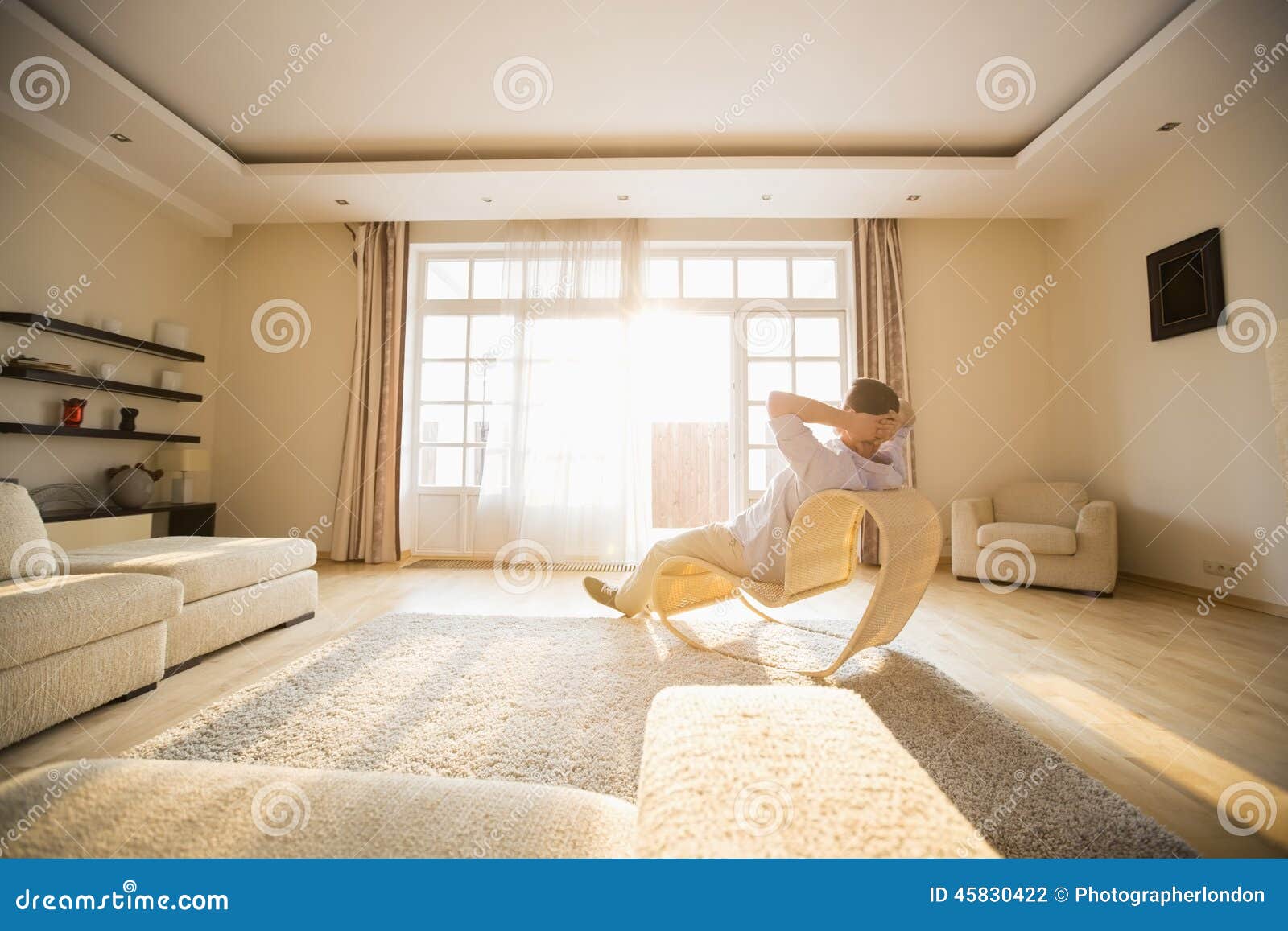 Rear View of Man Relaxing on Modern Chair at Home Stock Photo - Image ...