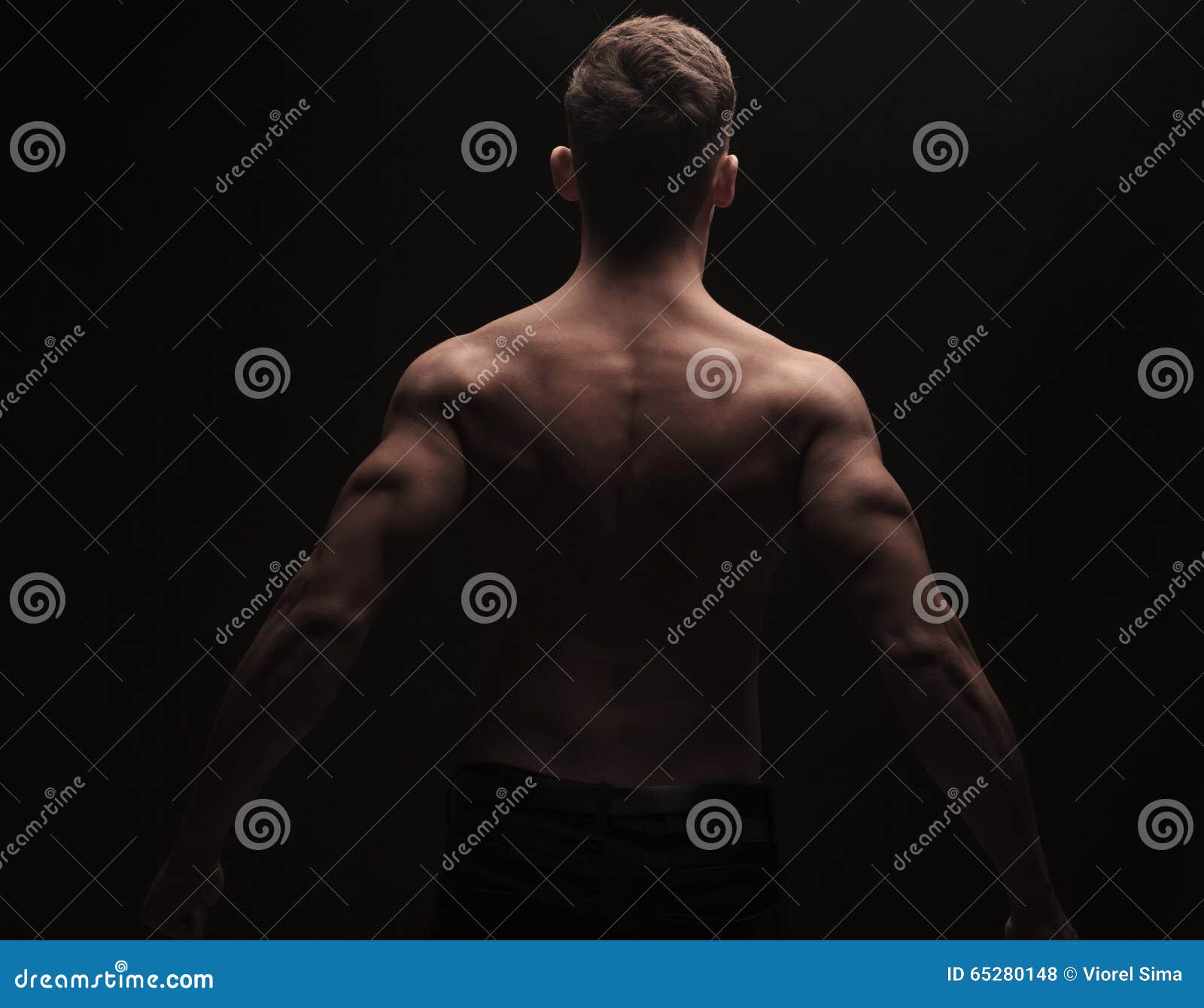 Rear View of Muscular Man Flexing His Back and Arms Stock Photo - Image ...