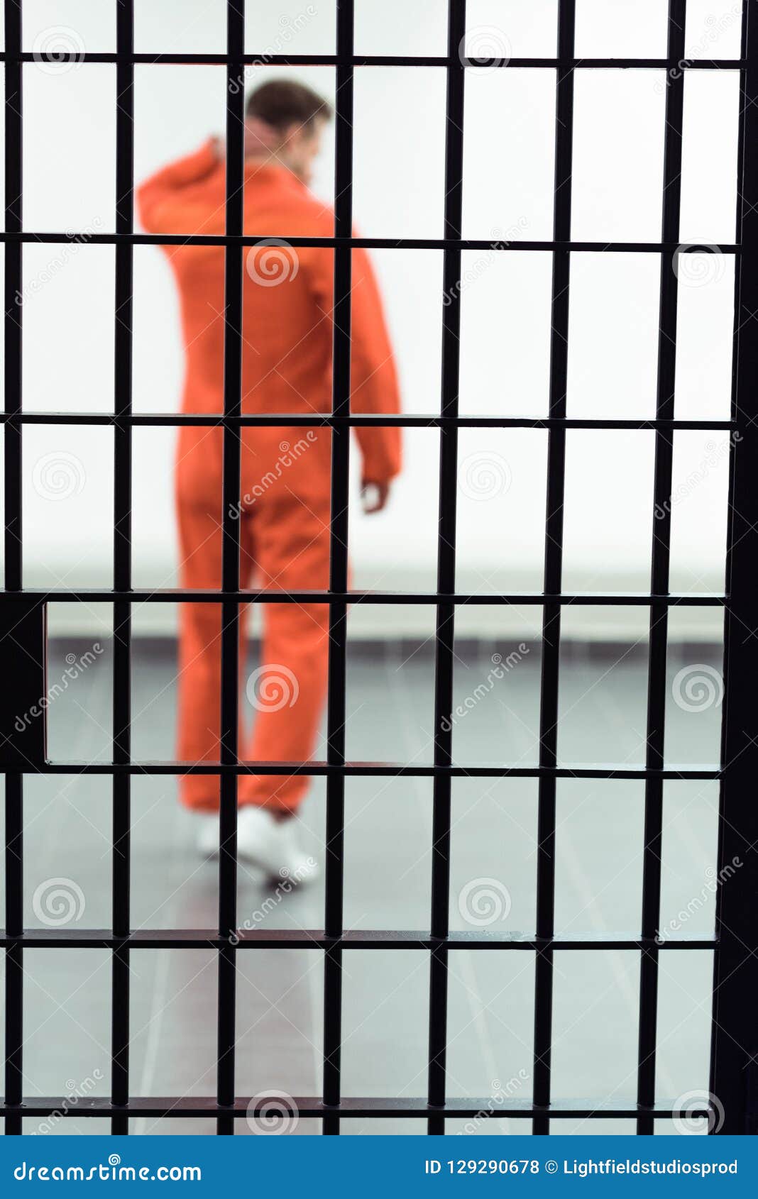 Rear View of Prisoner in Prison Cell with Metallic Bars Stock Photo ...