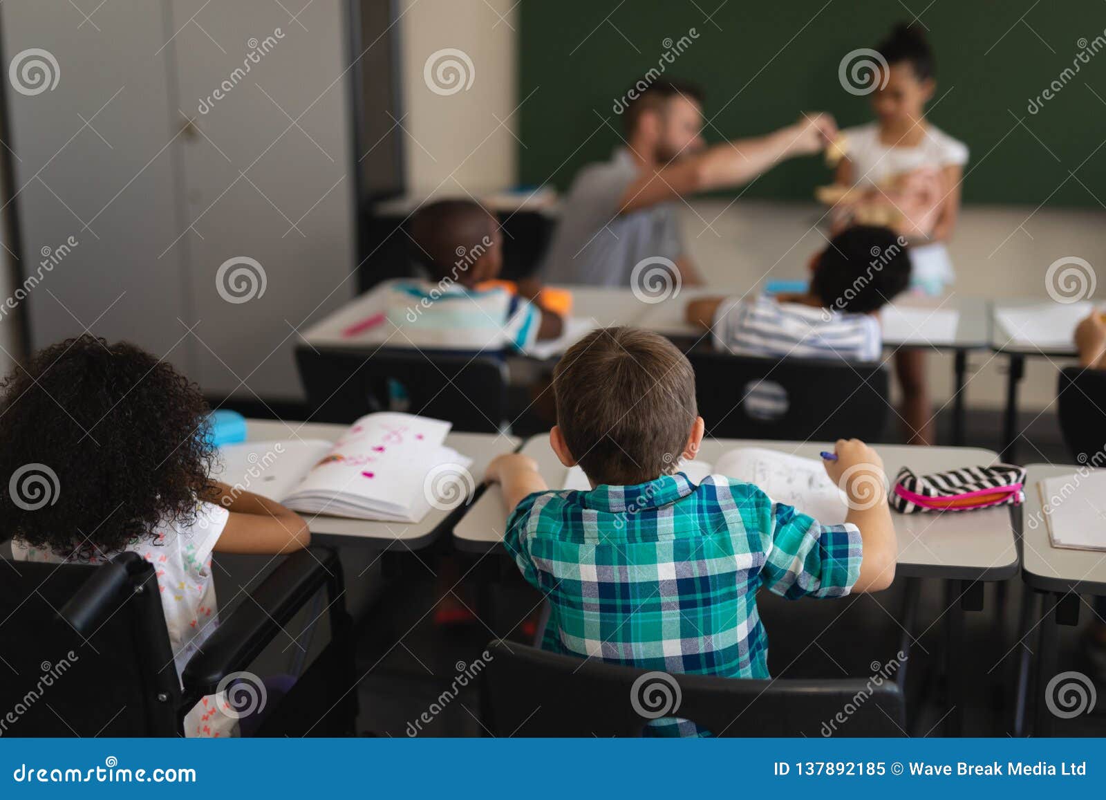 Rear View of Schoolkids Studying and Sitting at Desk in Classroom Stock ...