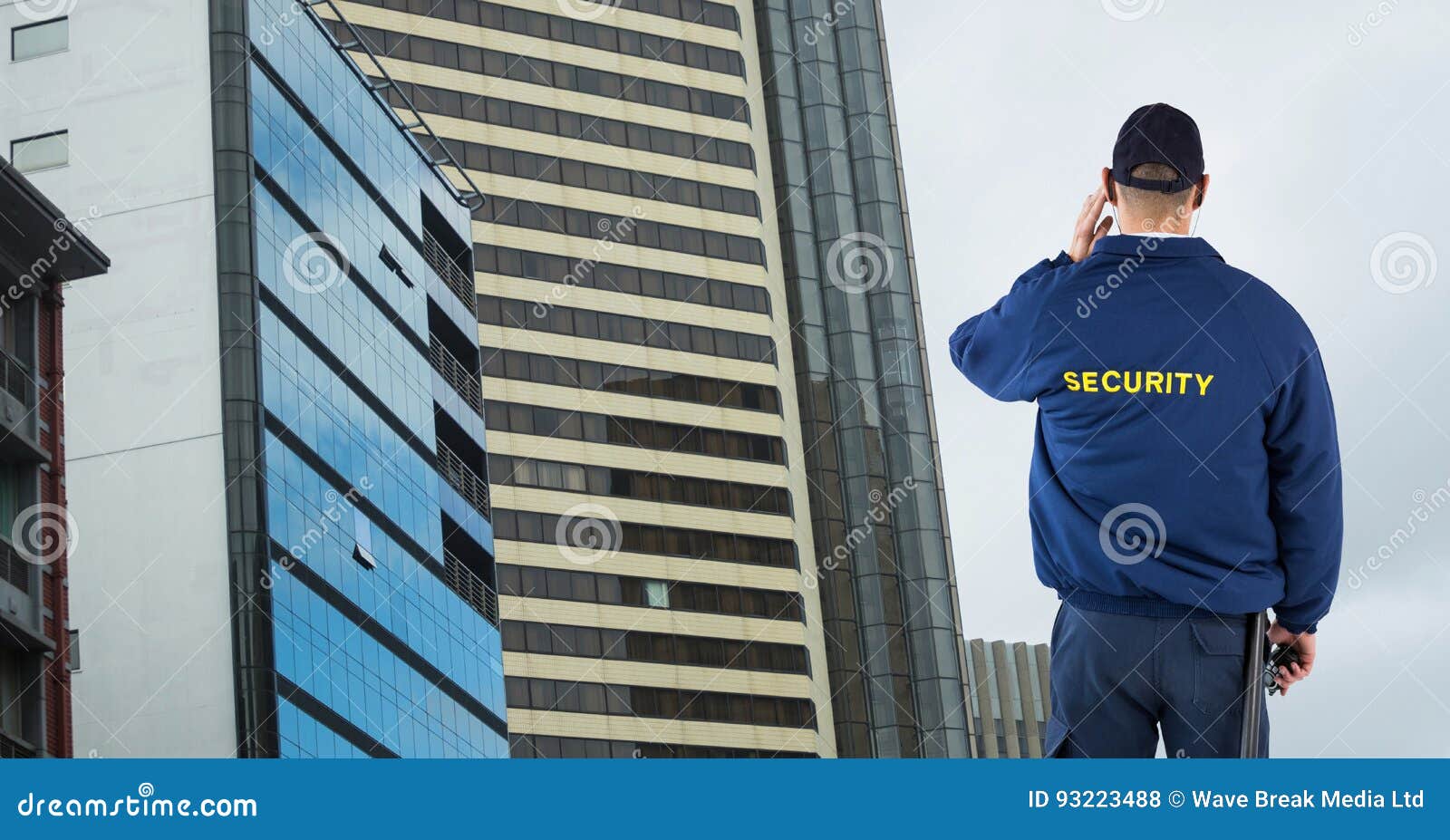 Rear View of Security Guard Talking on Bluetooth Device while Standing ...