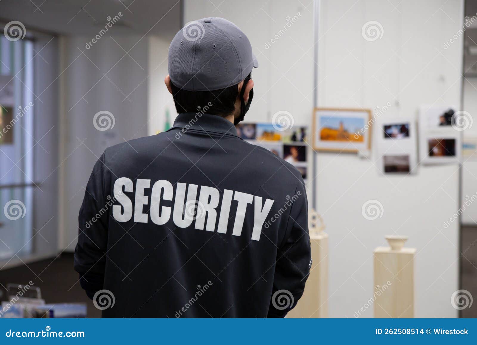 Rear View of a Security Guard in Uniform Patrolling in a Commercial ...