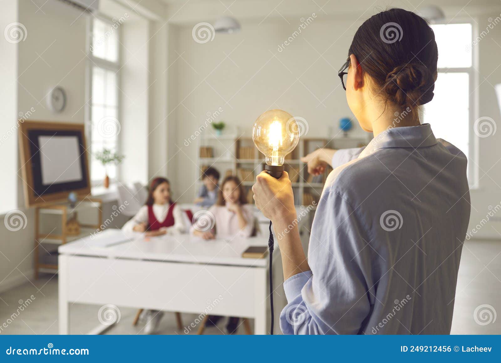 Rear View on Teacher with Lightbulb Pointing at Pupil Sitting at ...