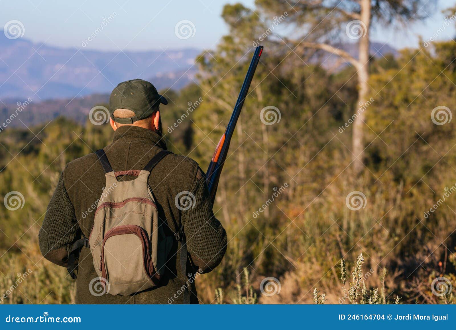 Hunter on His Back with His Gun Up Walking in Nature Stock Photo ...