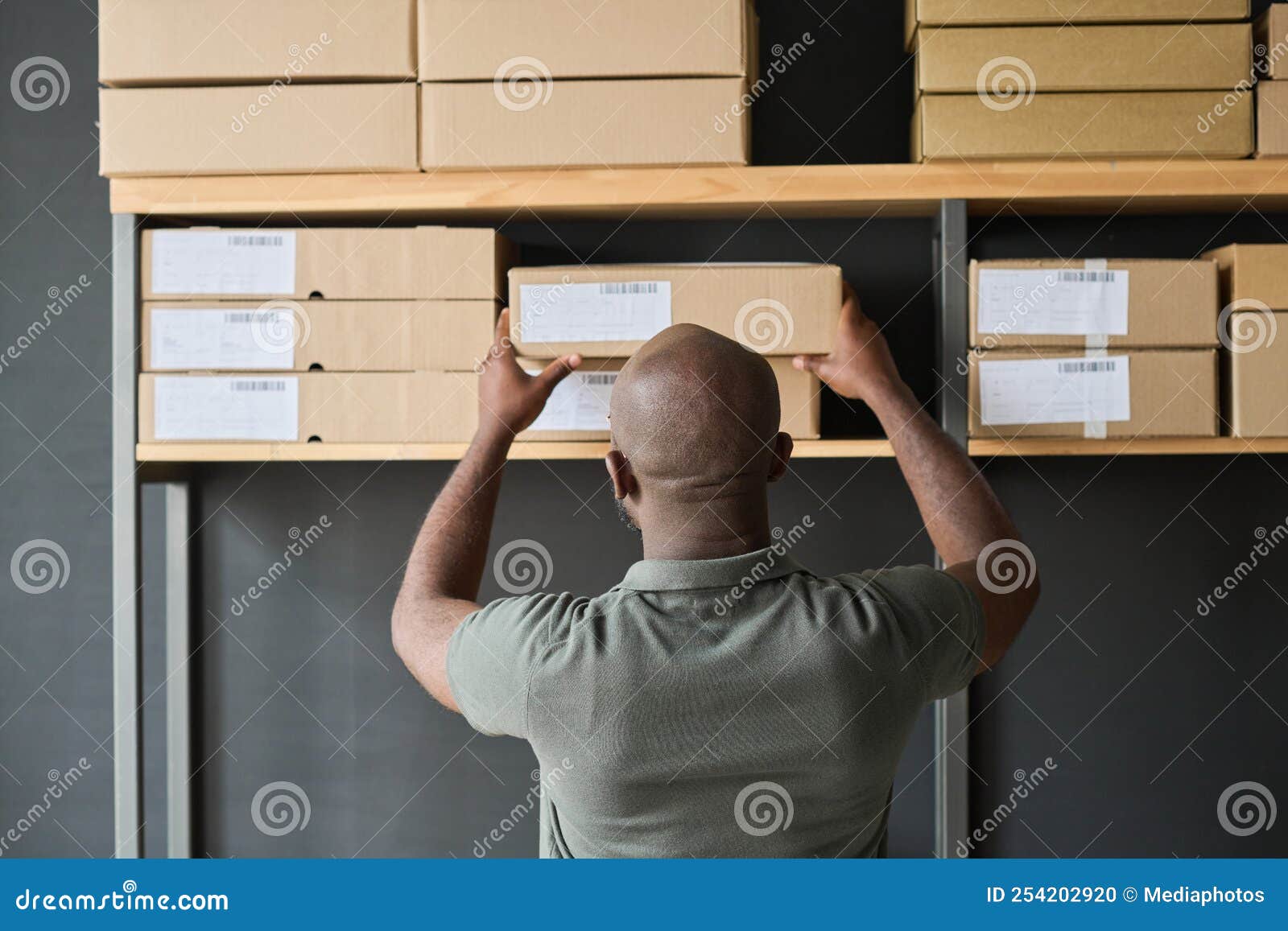 Warehouse Worker Putting Parcels on Shelf Stock Photo - Image of shelf ...