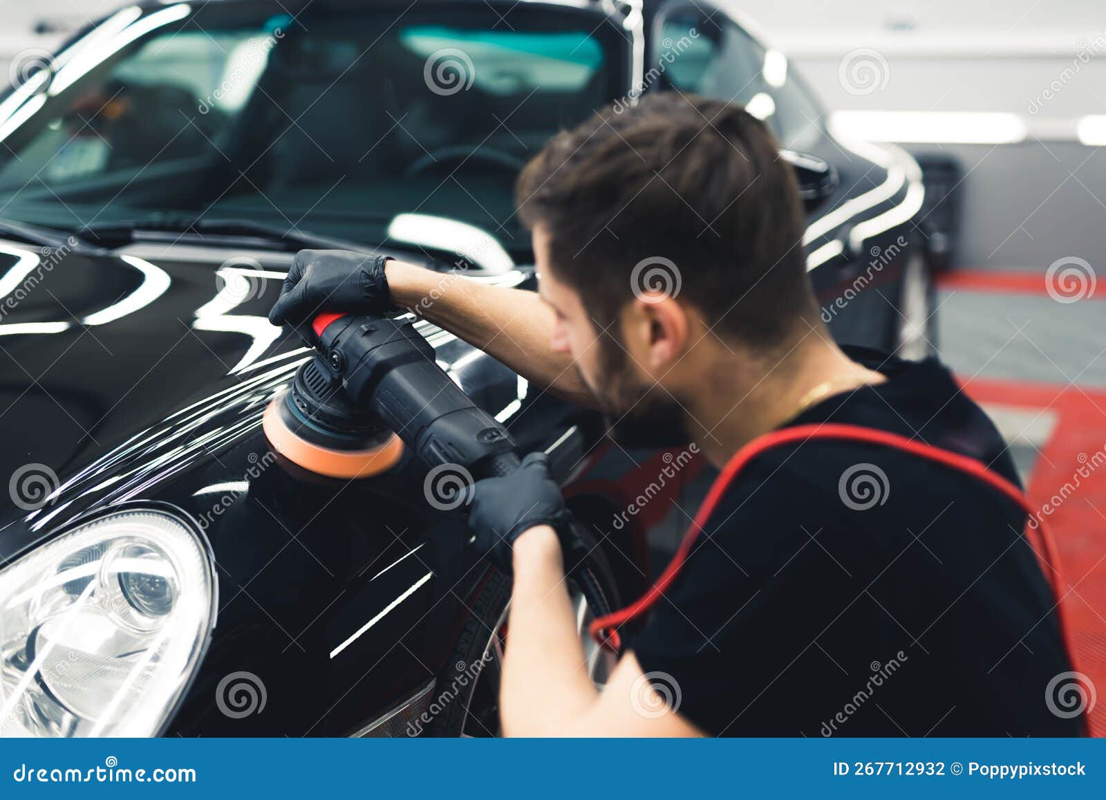 Rear View of White Man Crouching Polishing the Front of Black Car with ...
