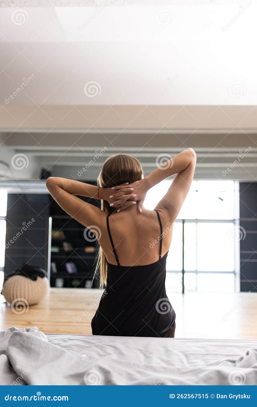 Rear View Of Woman Stretching In Bed After Wake Up In Morning Stock