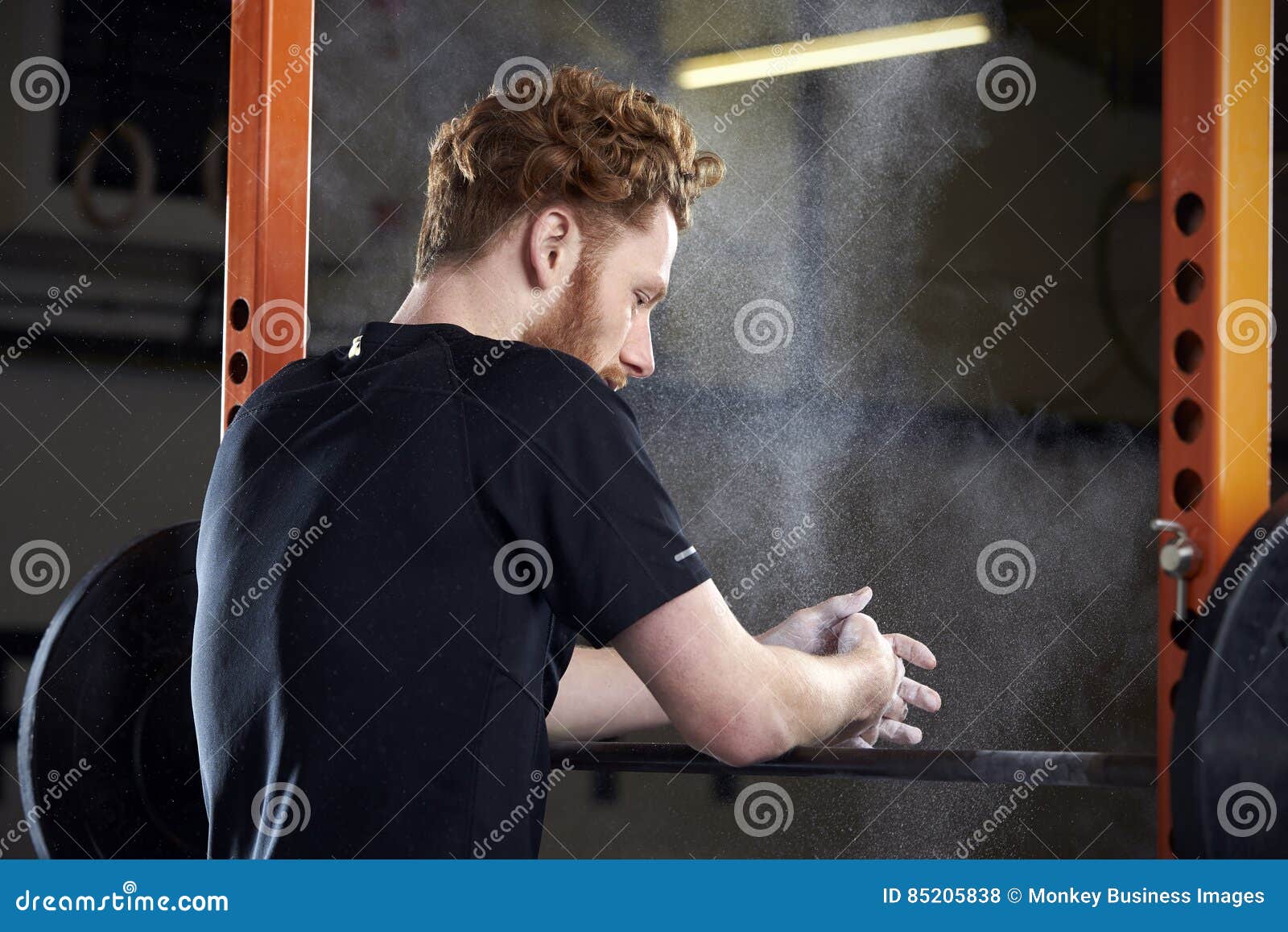 Rear View of Young Man in Gym Lifting Weights on Barbell Stock Photo ...