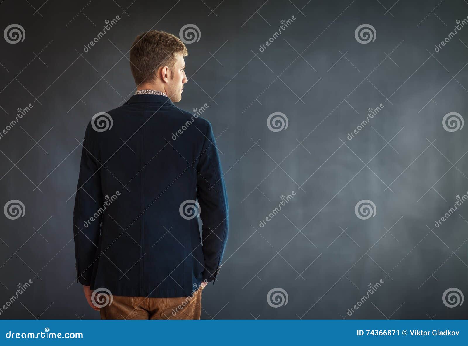 Rear View of Young Man Standing Against Grey Wall Background Stock ...