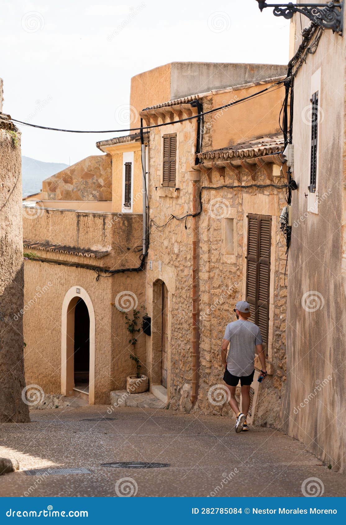 Rear View of Young Man Walking Alone through the Street of the Village ... Rear View of Young Man Walking Alone through the Street of the Village ...