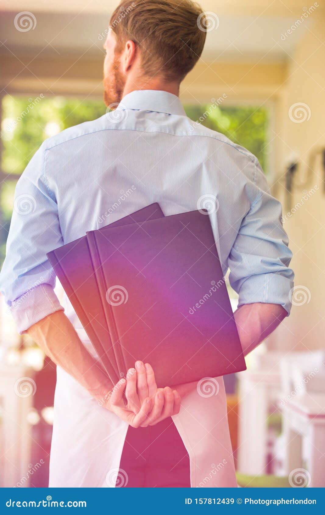 Rear View of Young Waiter Holding Menus while Standing at Restaurant ...