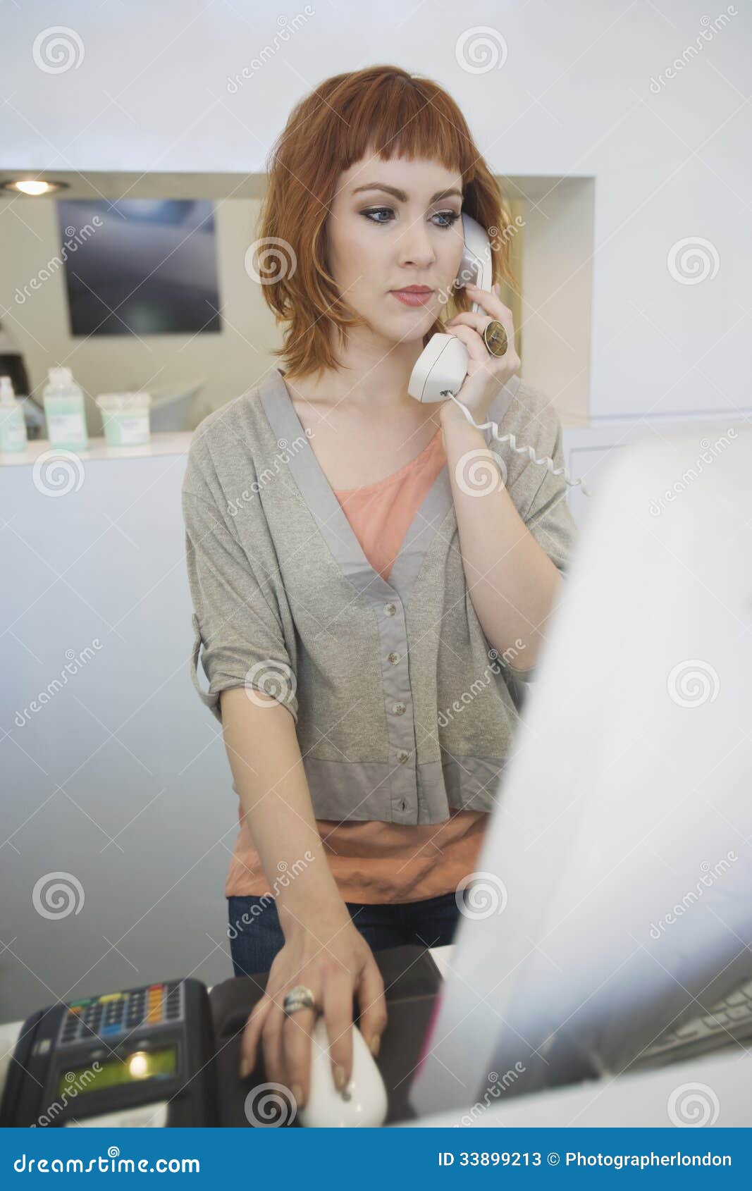 Receptionist Answering Telephone at Reception Desk Stock Image - Image ...