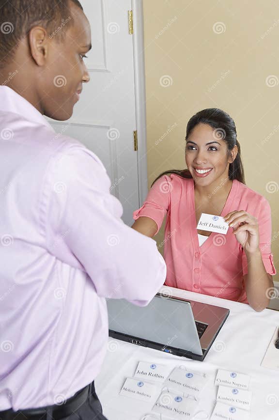Receptionist Distributing Name Tags Stock Photo - Image of holding ...