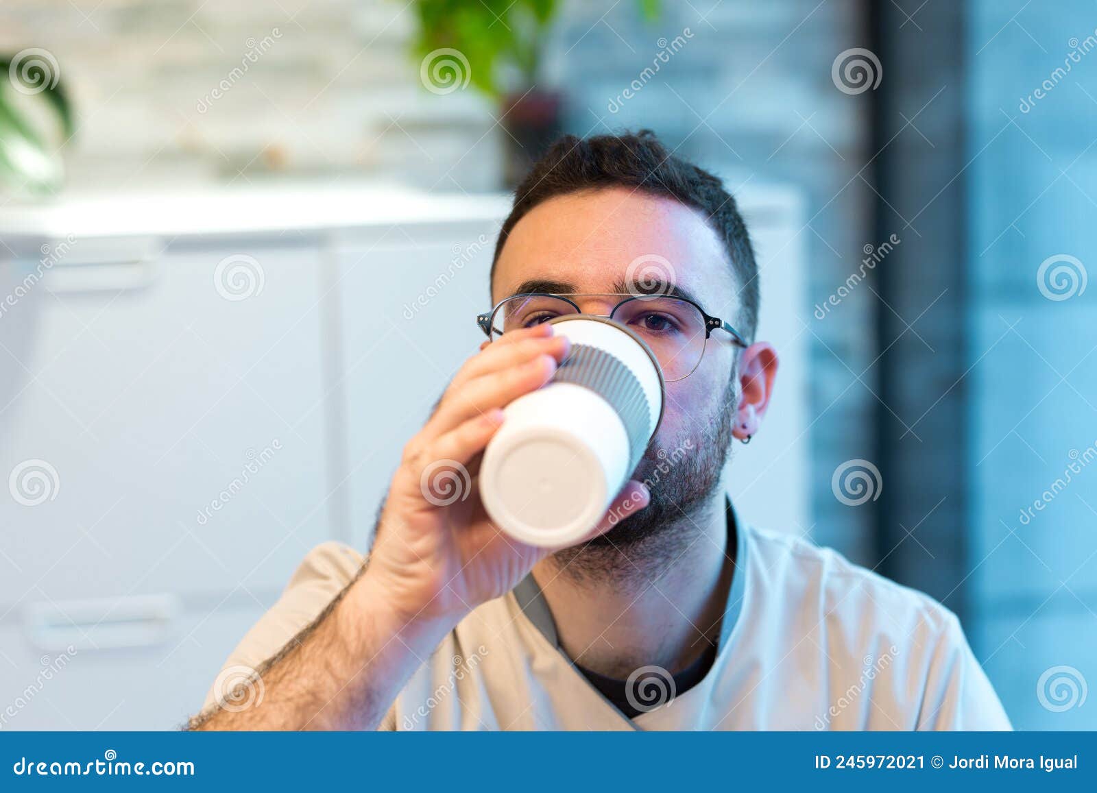 Receptionist Drinking Coffee from His Reusable Cup at Reception in ...