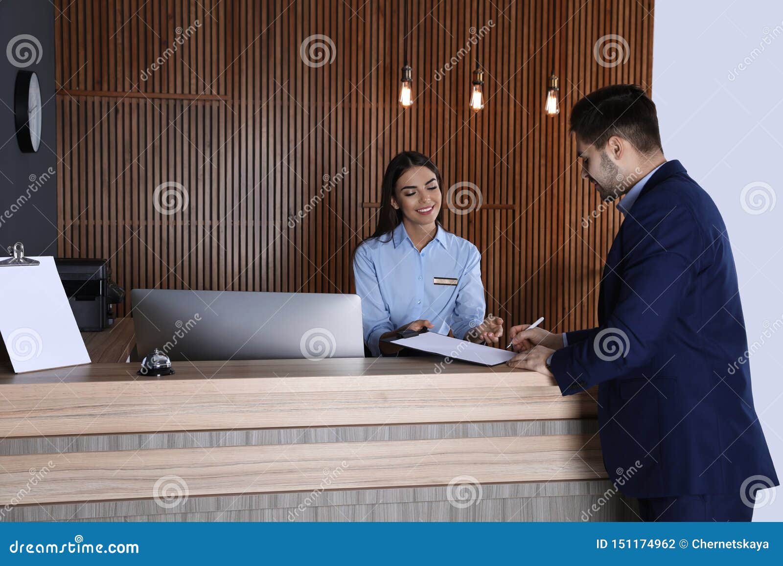 Receptionist Registering Client at Desk Stock Photo - Image of ...