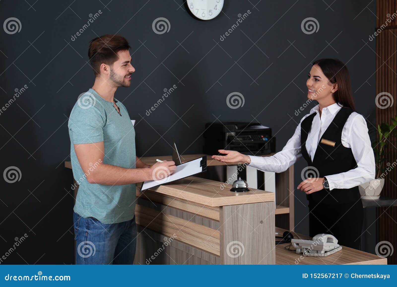 Receptionist Registering Client at Desk Stock Image - Image of office ...